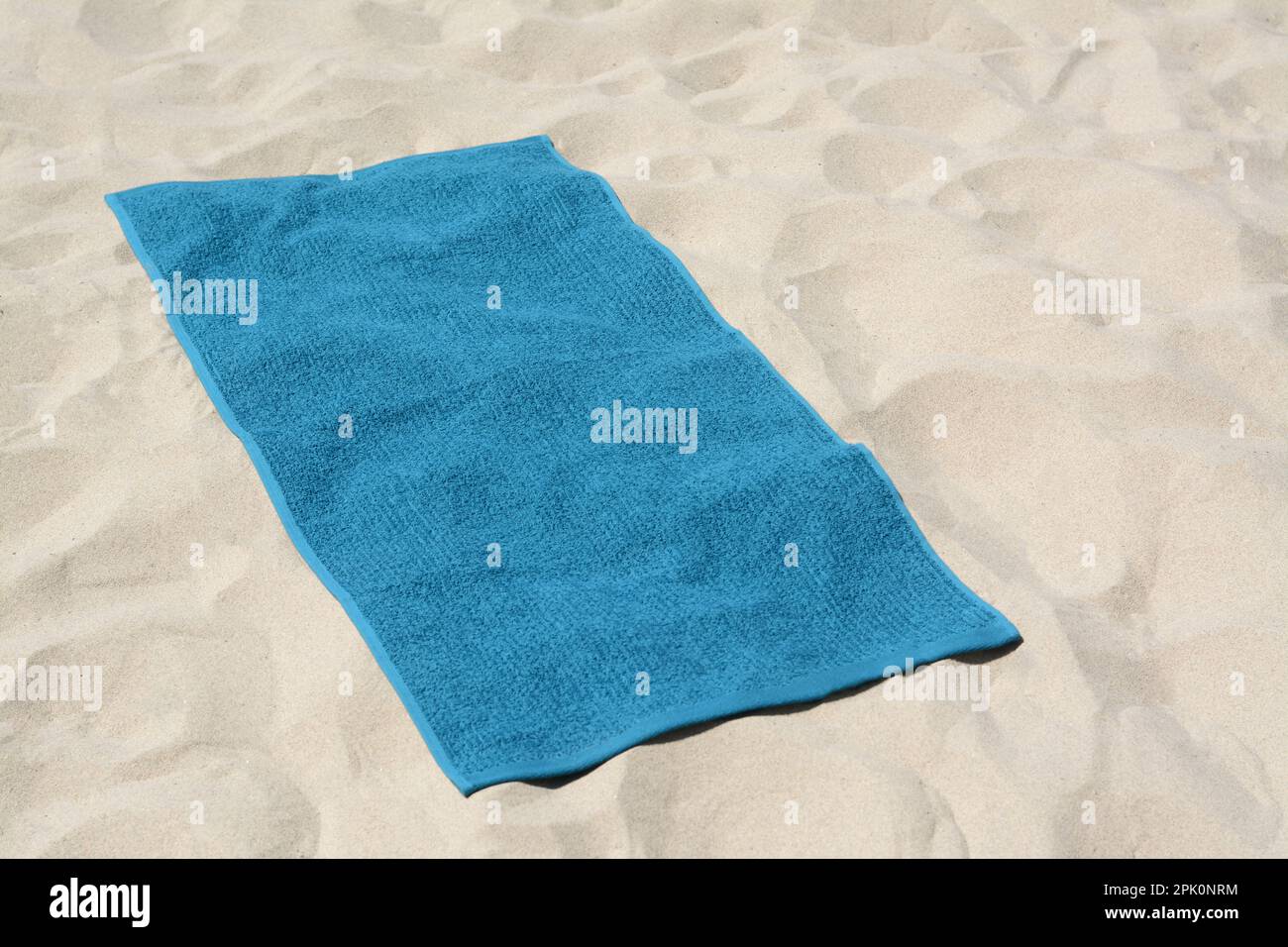 Beautiful soft blue towel on sandy beach Stock Photo - Alamy
