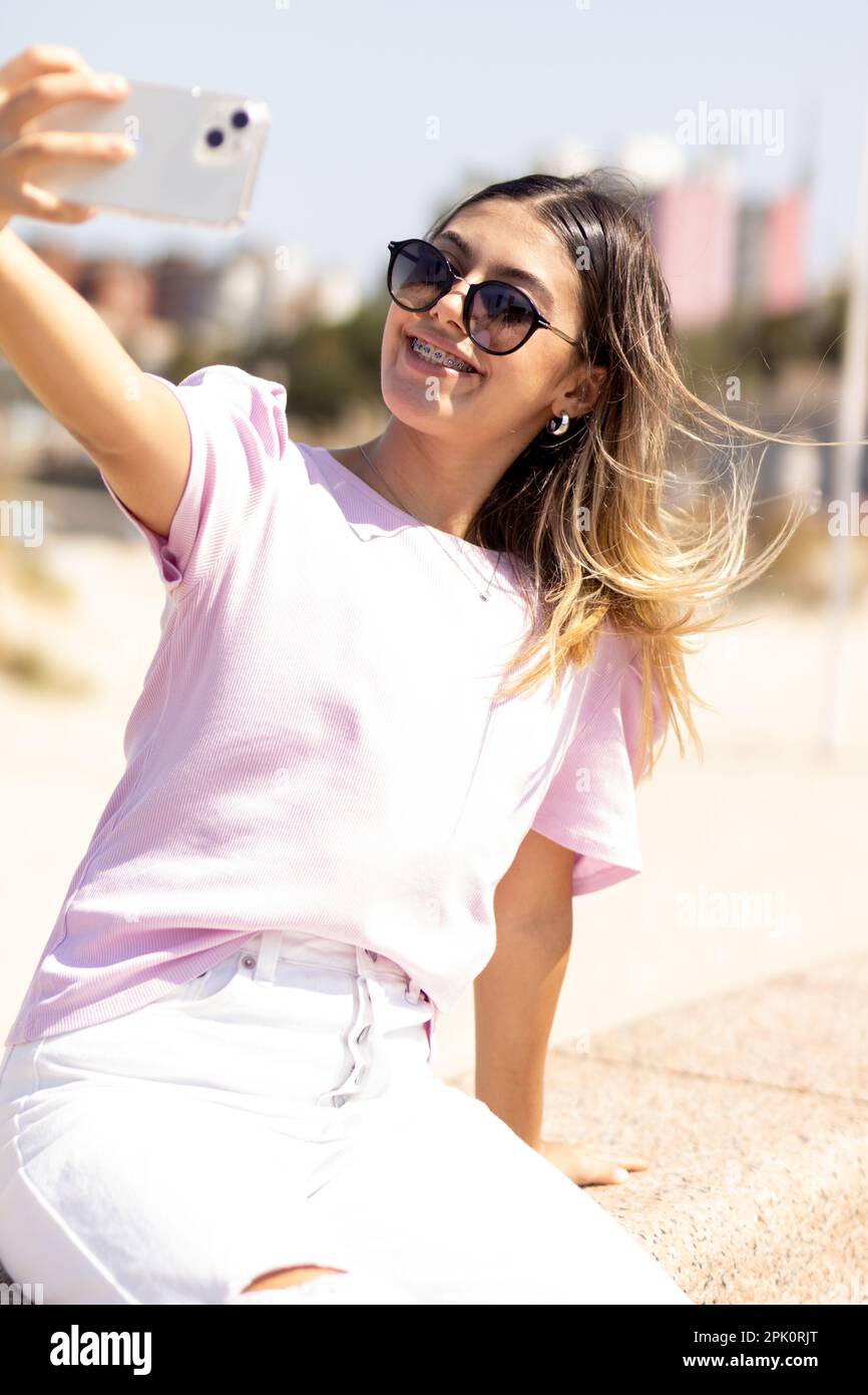 Teenager girl laughing taking a selfie with her smartphone on the ...