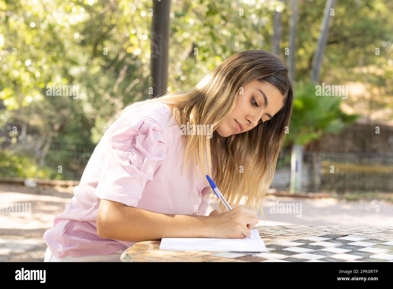 Concentrated teenager girl writing in a book Stock Photo - Alamy
