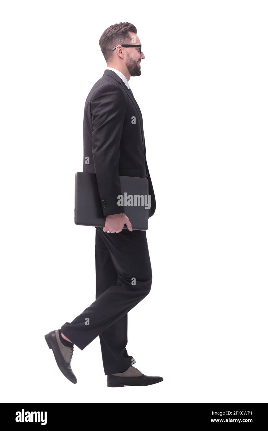 in full growth. successful businessman with laptop stepping forward ...