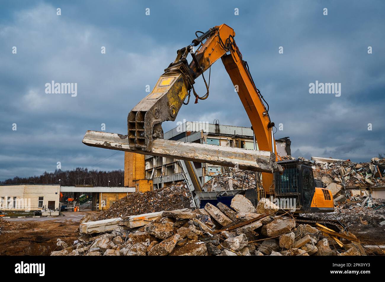 Excavator with hydraulic press breaks concrete leftovers Stock Photo - Alamy