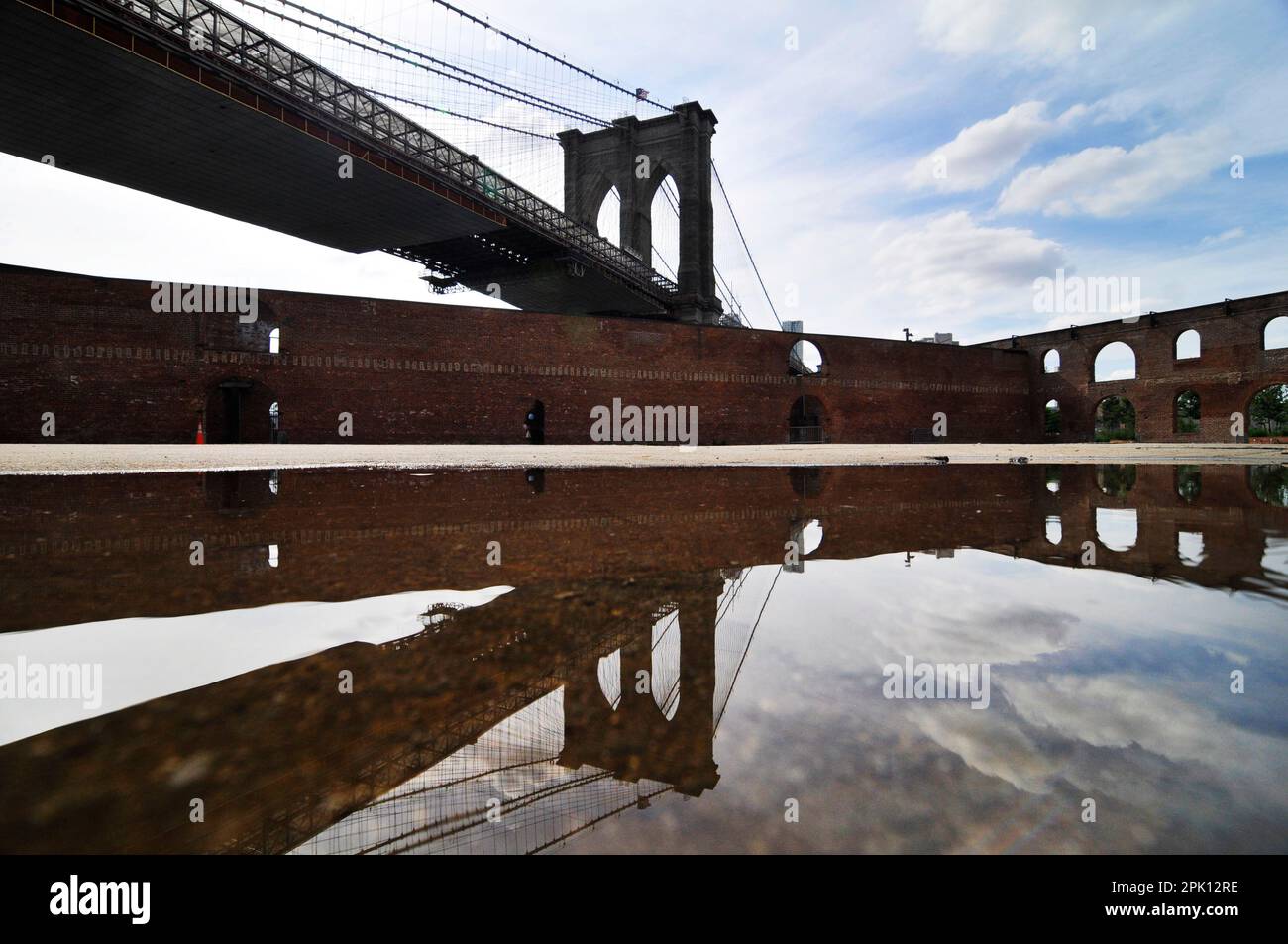The Brooklyn bridge seen through an old red brick warehouse on the ...