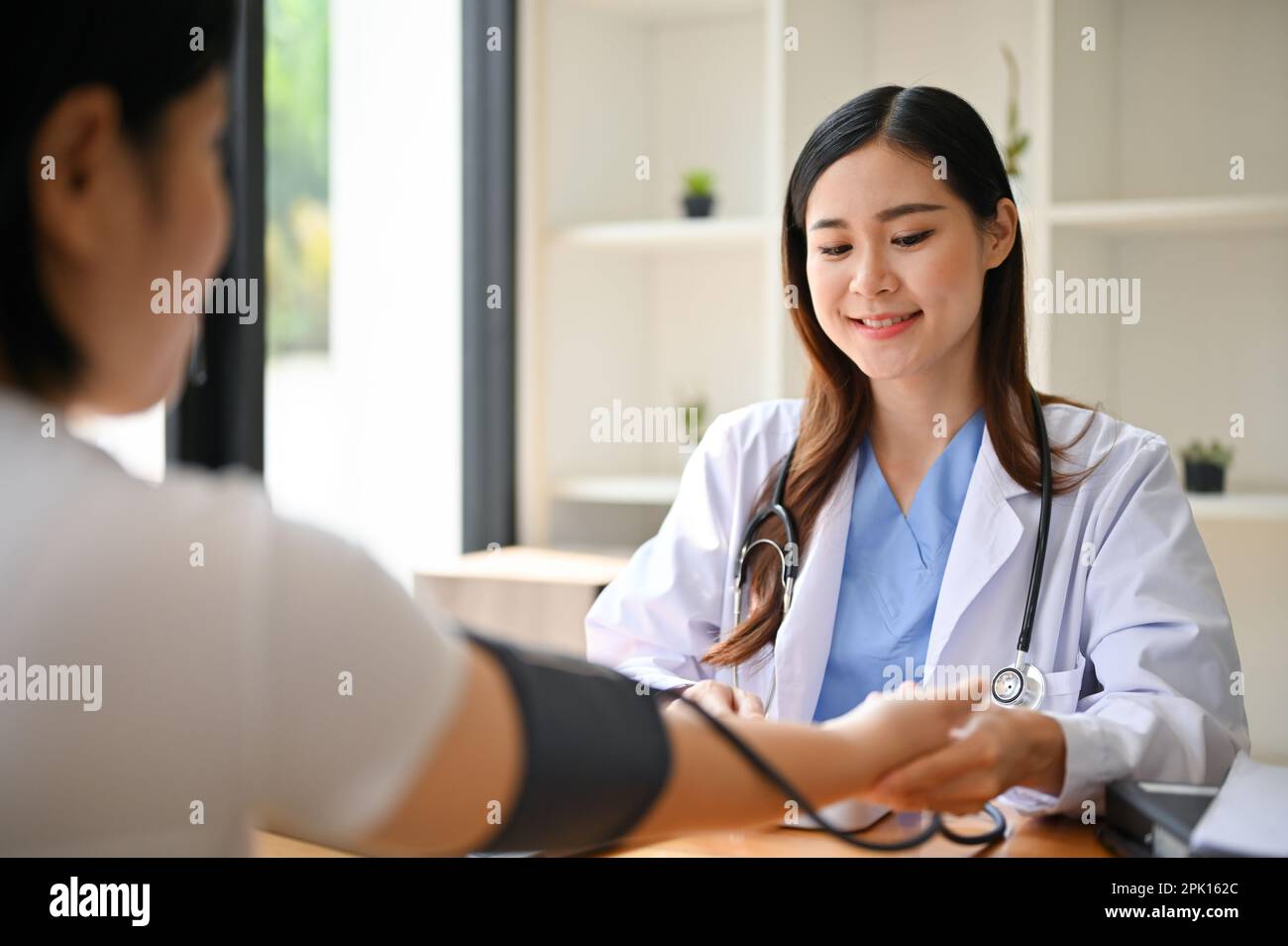 A professional Asian female doctor checking patient's pulse, heart rate ...