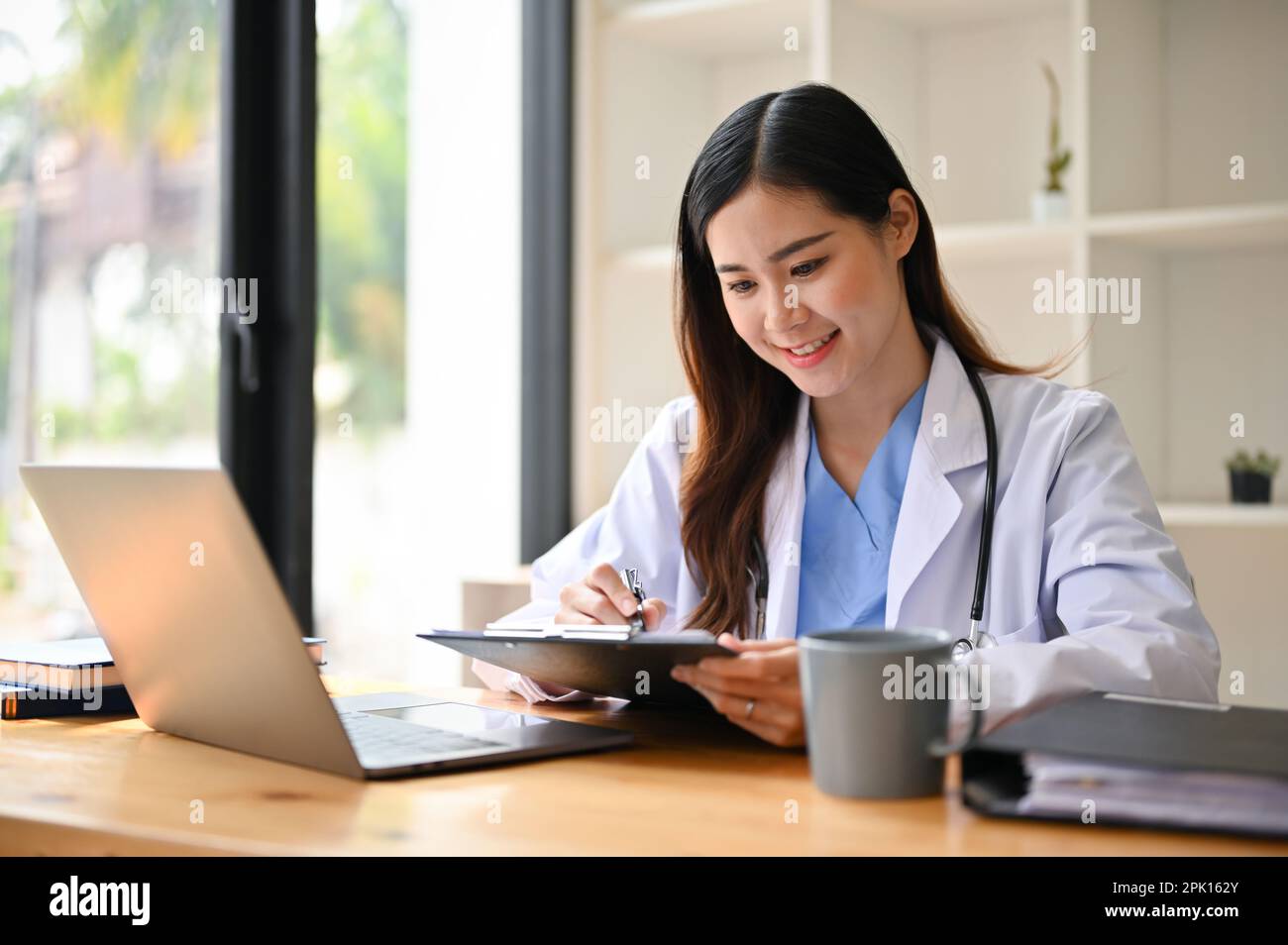 Attractive and professional millennial Asian female doctor checks her ...