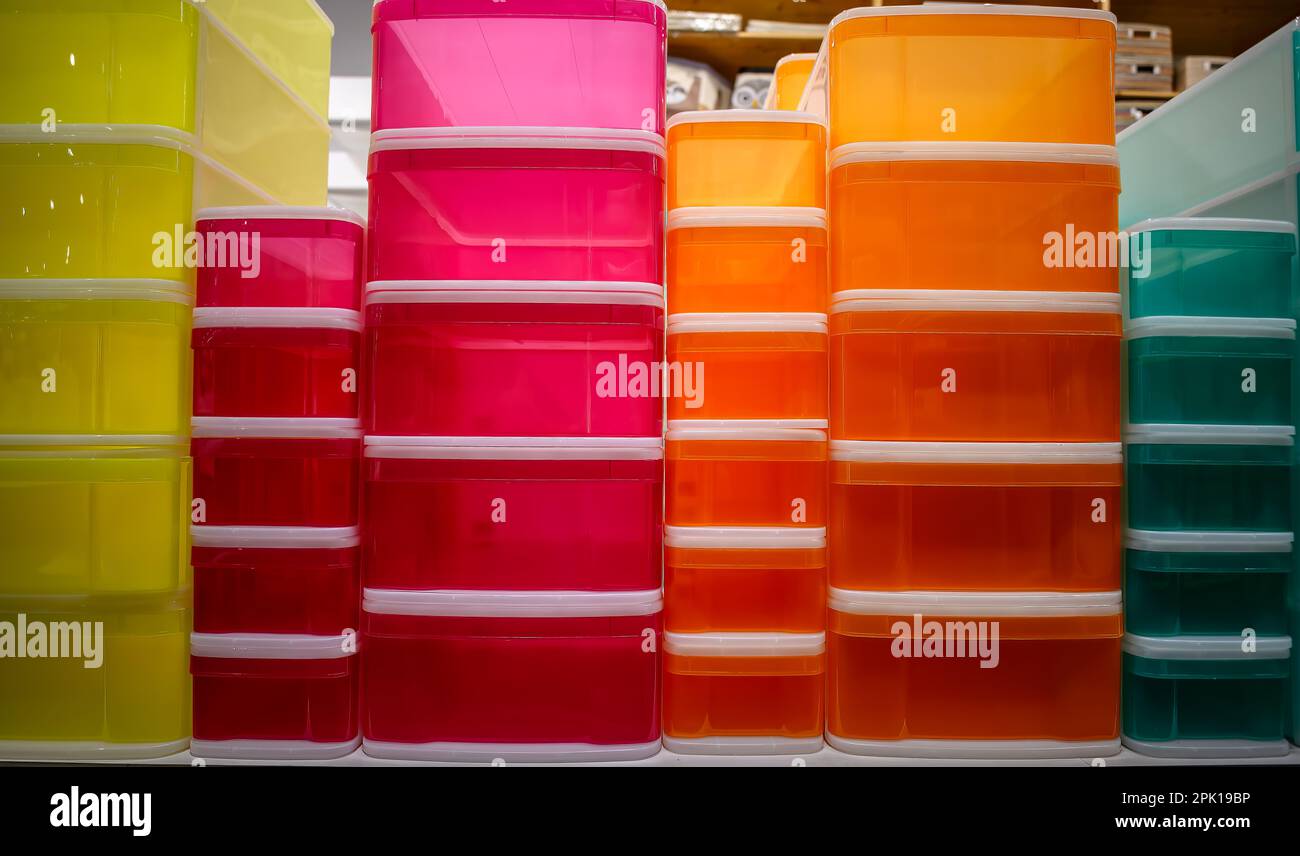 Rows of multi-colored storage bin totes in a retail store shelving ...