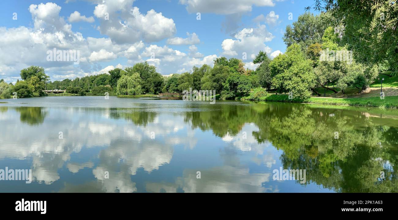 panoramic summer park landscape with river and trees. blue cloudy sky ...