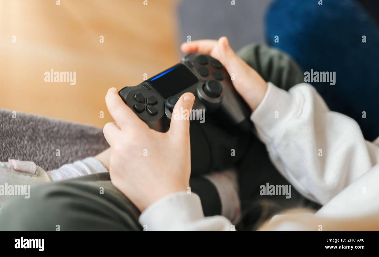 A little girl holding game controller playing video games Stock Photo ...