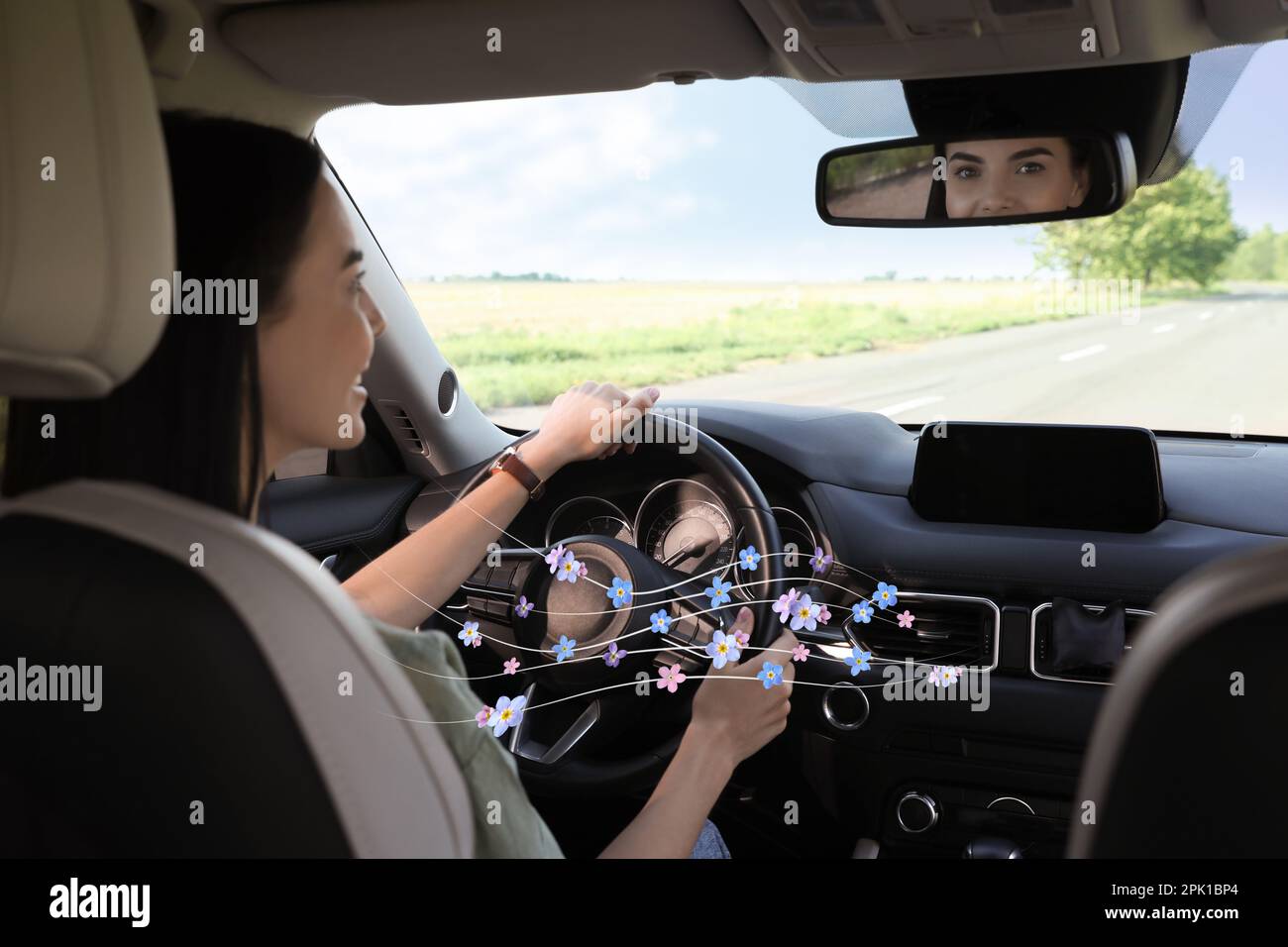 Woman enjoying driving car feeling flower scent from ventilation ...