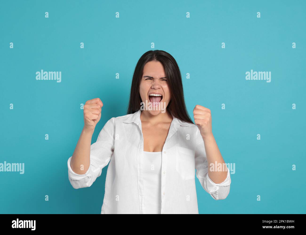 Aggressive young woman shouting on turquoise background Stock Photo - Alamy