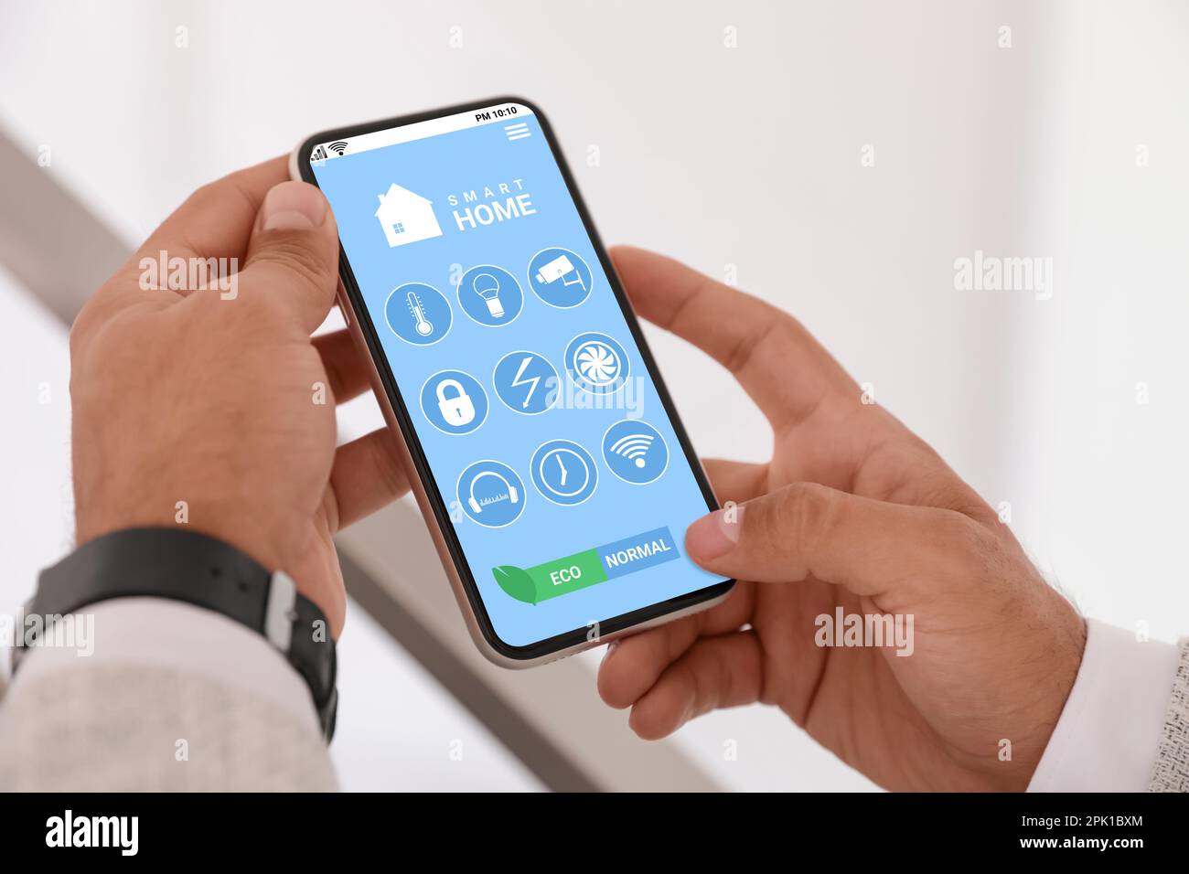 Man using Smart Home app on mobile phone indoors, closeup Stock Photo ...