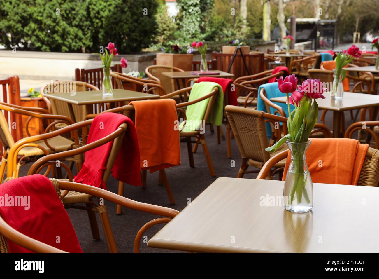Outdoor cafe with wicker chairs and wooden tables Stock Photo - Alamy