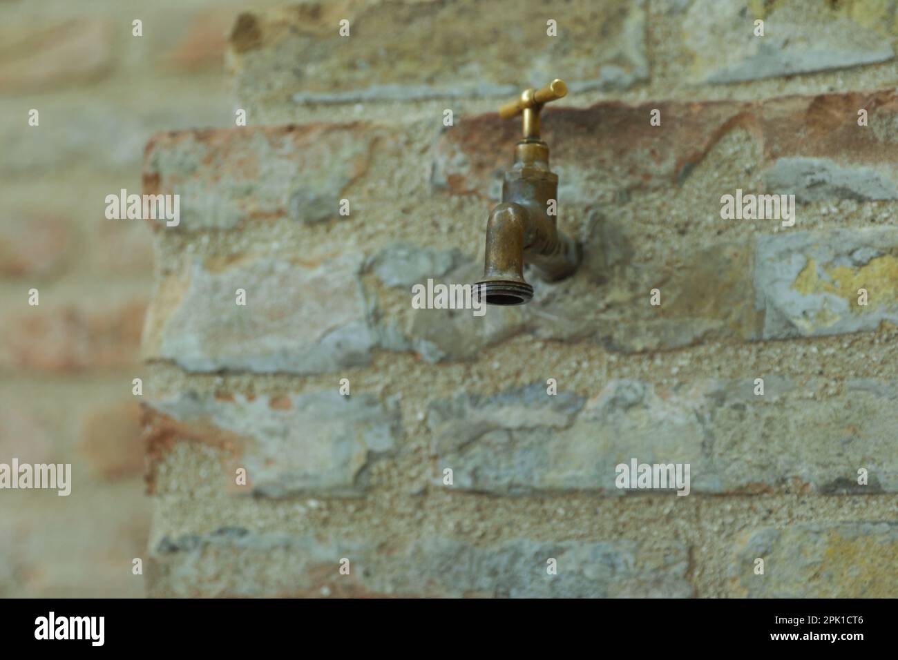 Metal water tap on old brick wall outdoors Stock Photo - Alamy