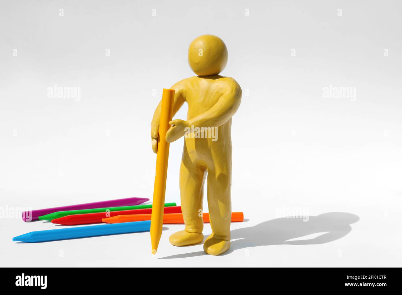 Human figure made of plasticine drawing with yellow pencil on white ...