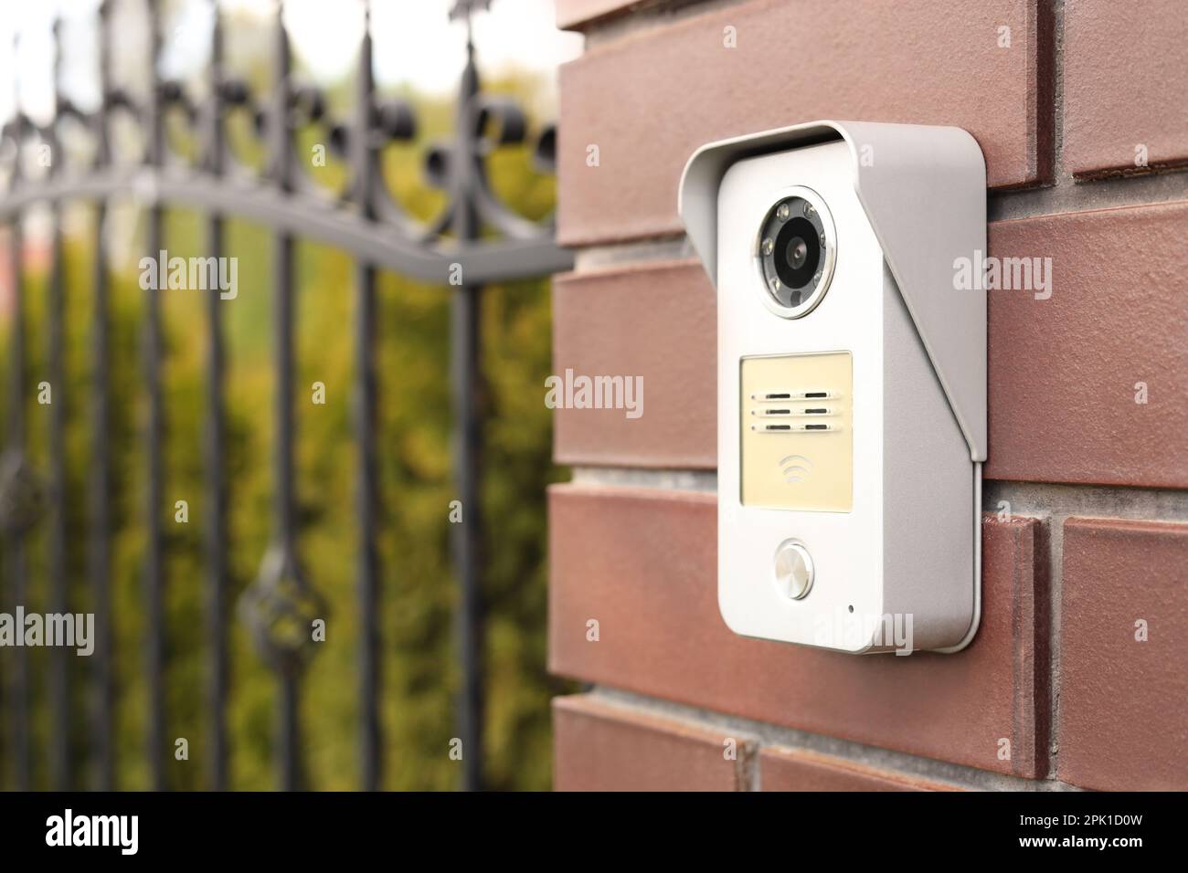 Modern intercom on red wall near gates outdoors, space for text Stock ...