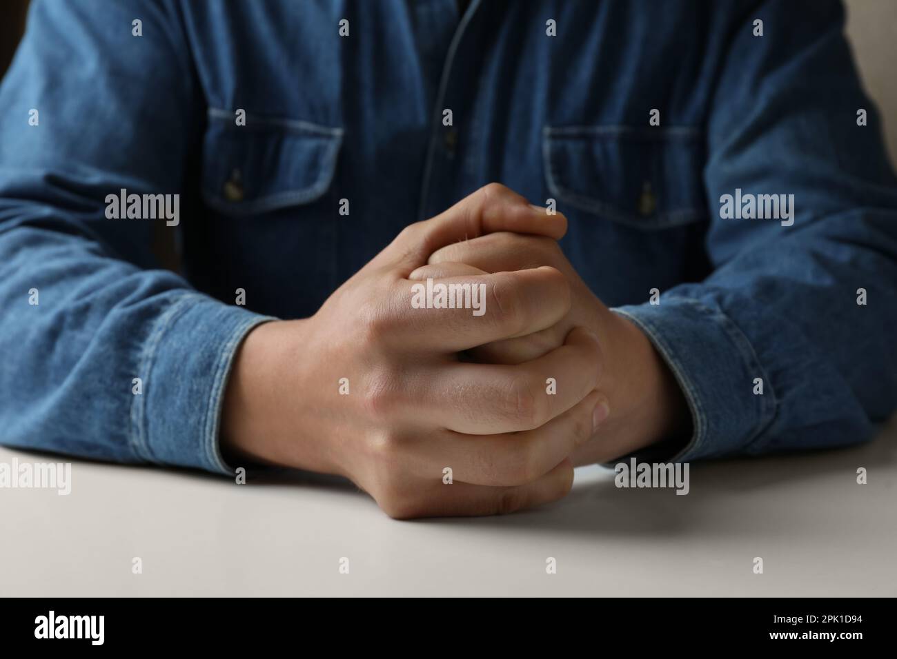 Man clenching hands at table while restraining anger, closeup Stock ...