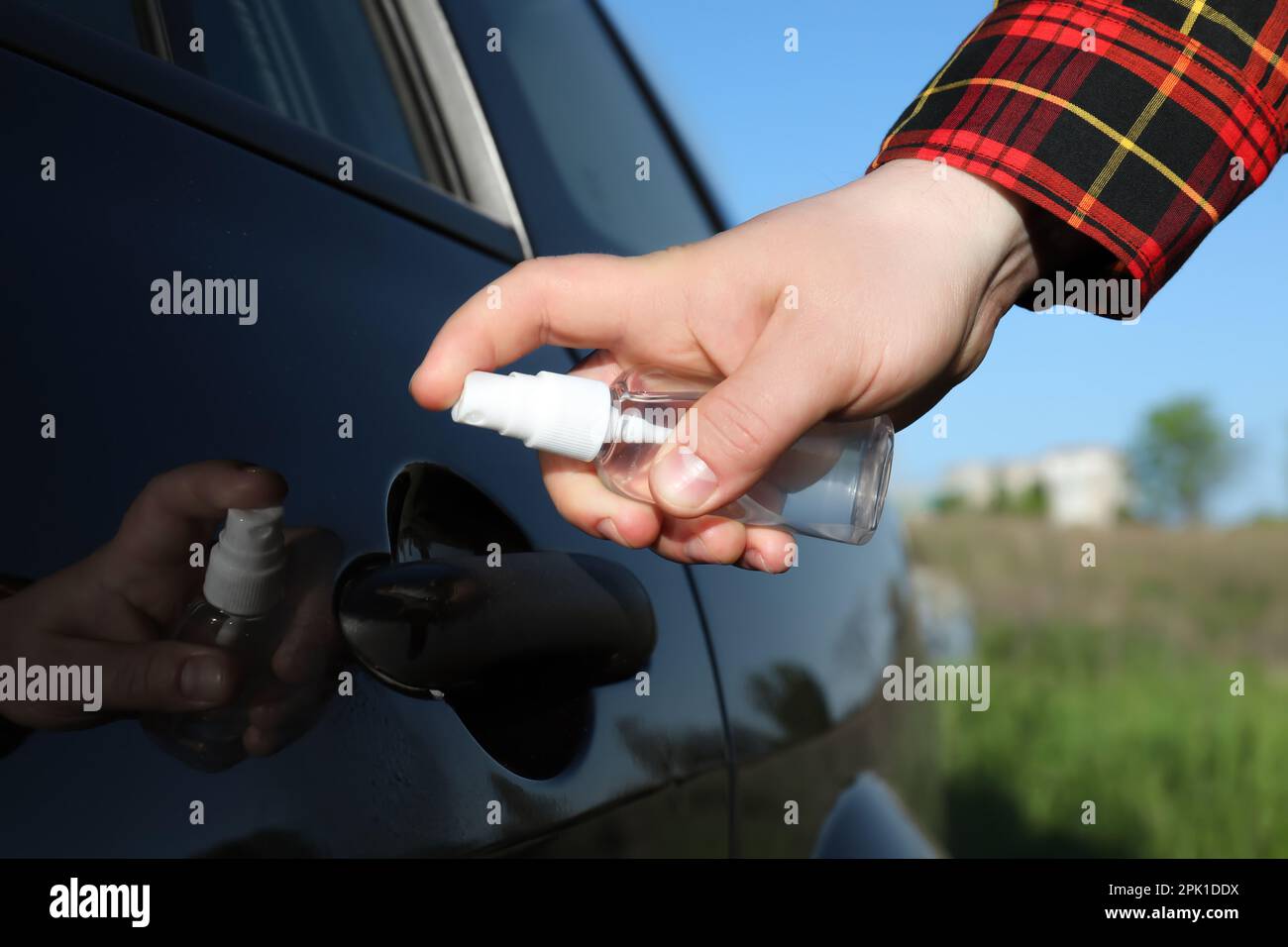 Closeup view of man disinfecting car door handle outdoors Stock Photo ...
