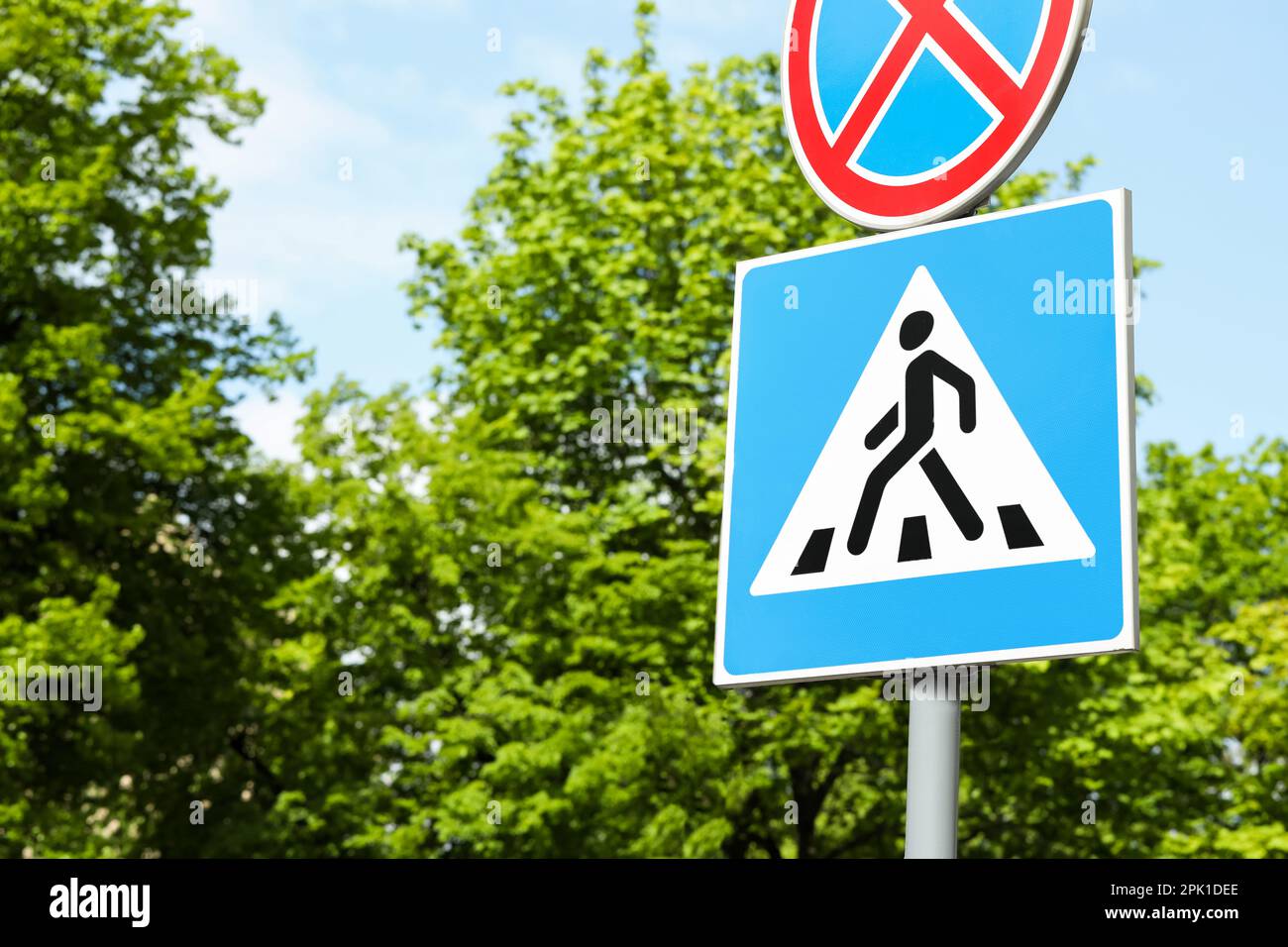 Post with Pedestrian Crossing and No Stopping road signs on sunny day ...
