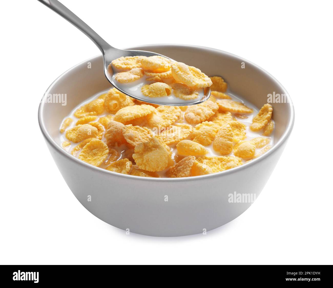 Spoon of delicious crispy corn flakes with milk above bowl on white ...