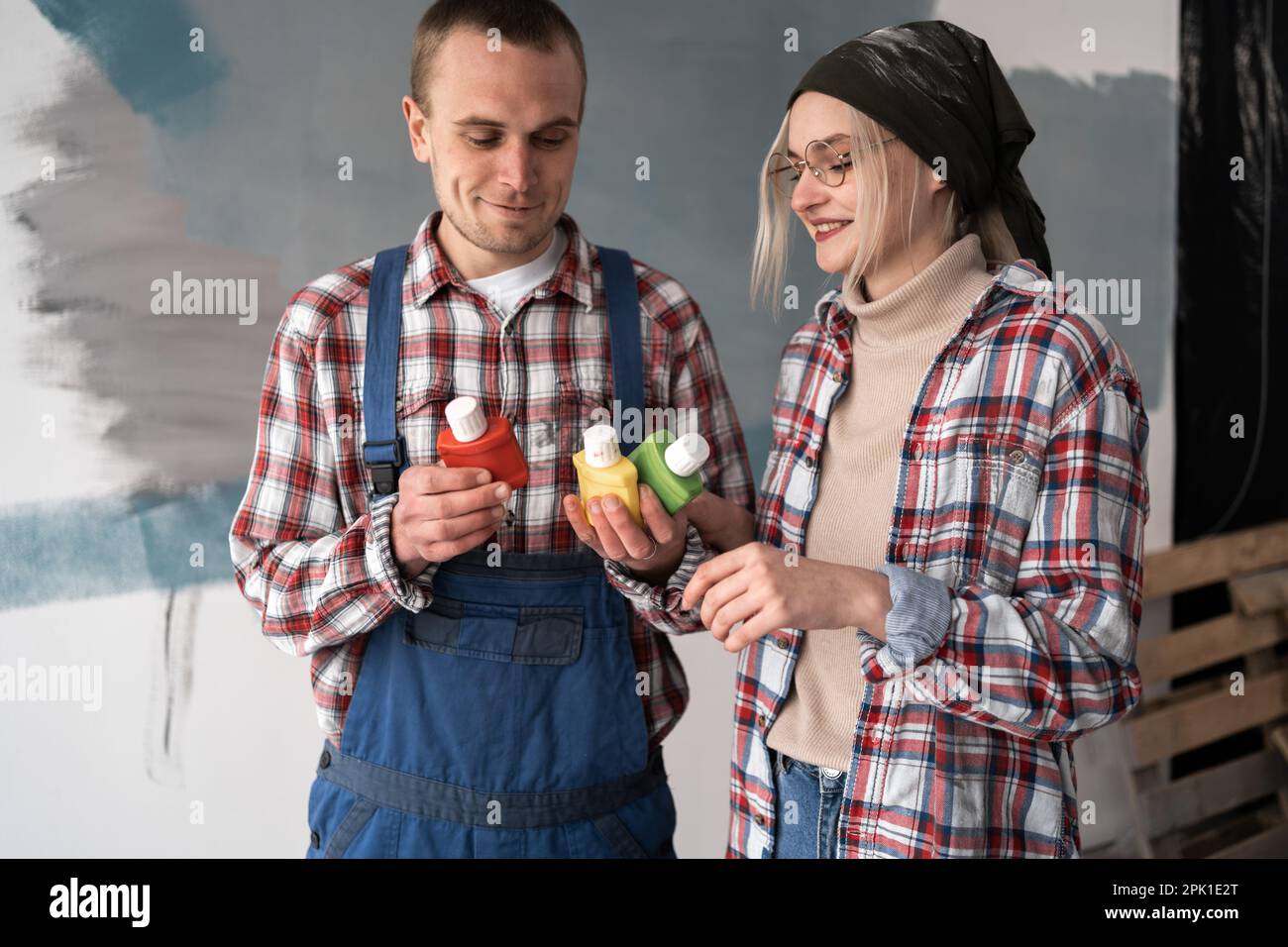 Happy young couple looking at color dye samples at home. Repair ...