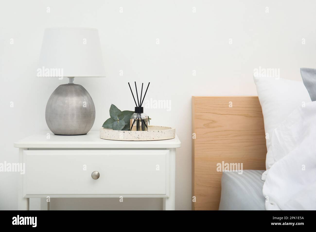 Reed diffuser with lamp and eucalyptus on nightstand in bedroom Stock ...