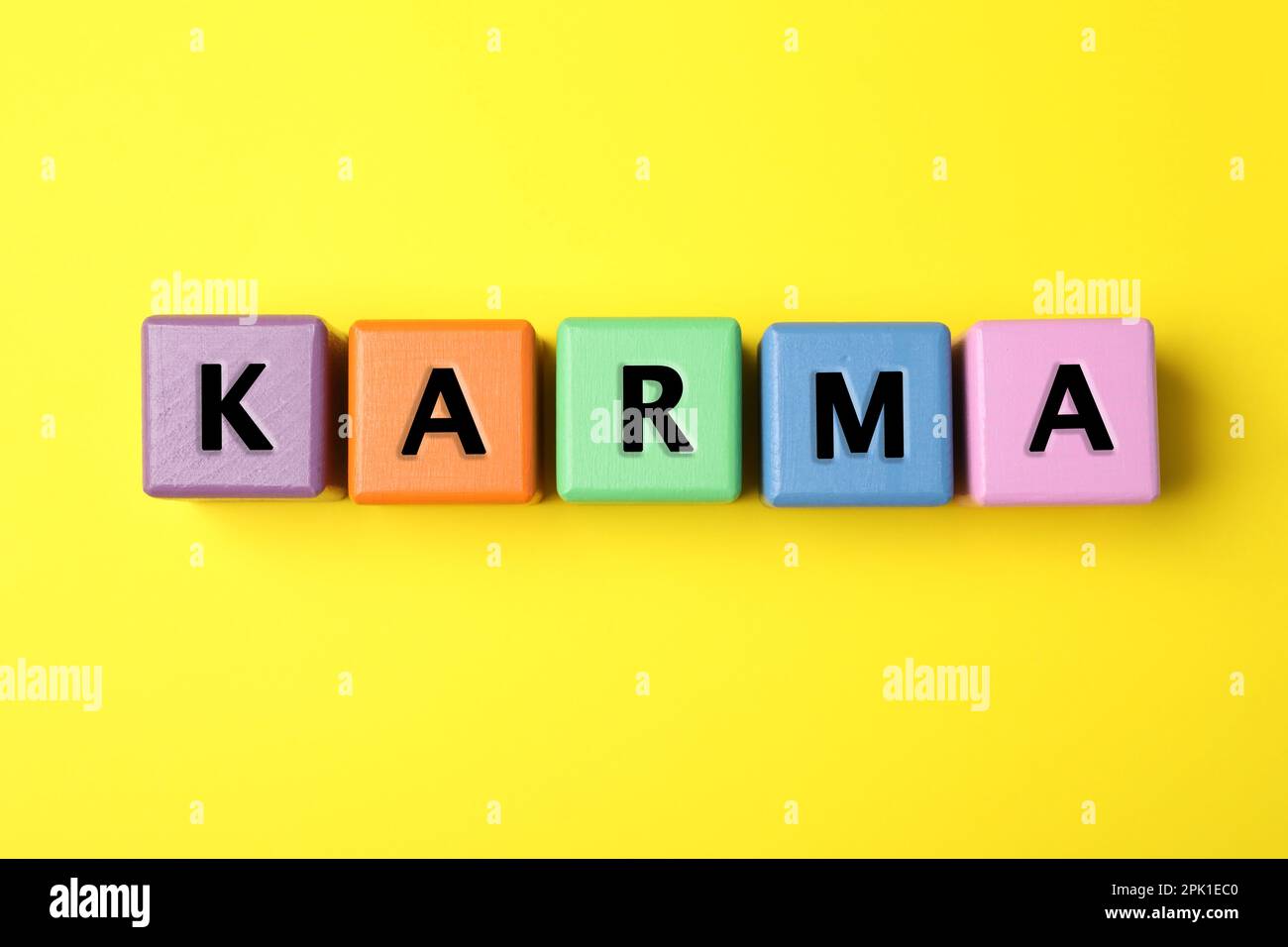 Word Karma made of colorful cubes with letters on yellow background ...