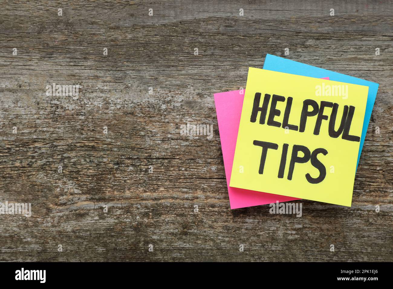 Paper note with phrase Helpful Tips on wooden table, top view. Space ...