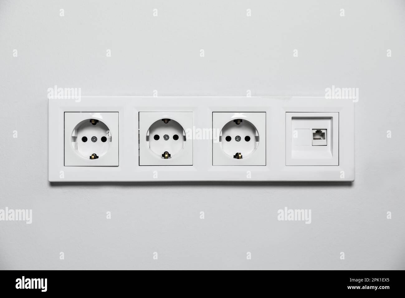 Power sockets on white wall. Electrical supply Stock Photo - Alamy