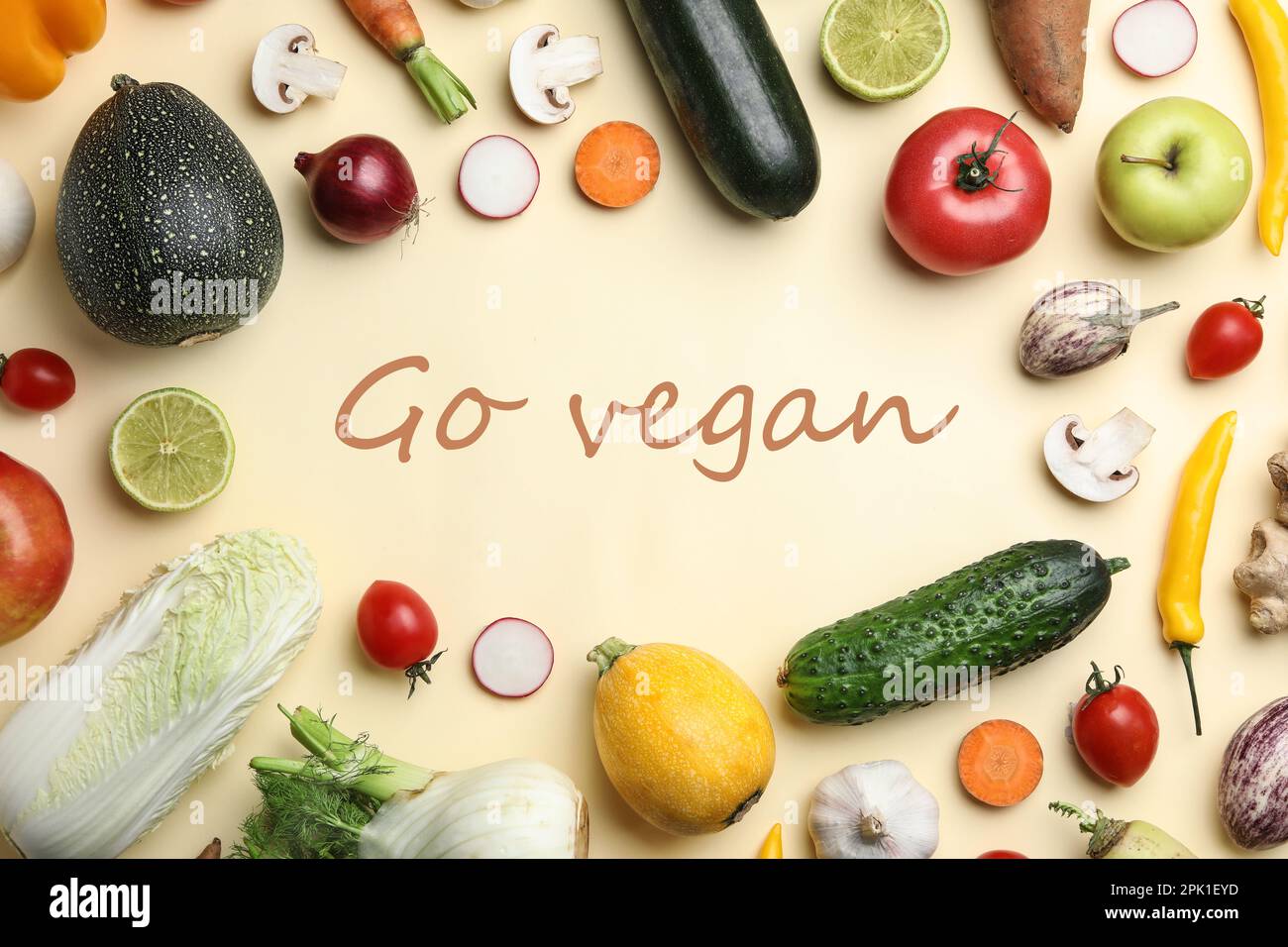 Phrase Go Vegan, fresh vegetables and fruits on beige background, flat ...