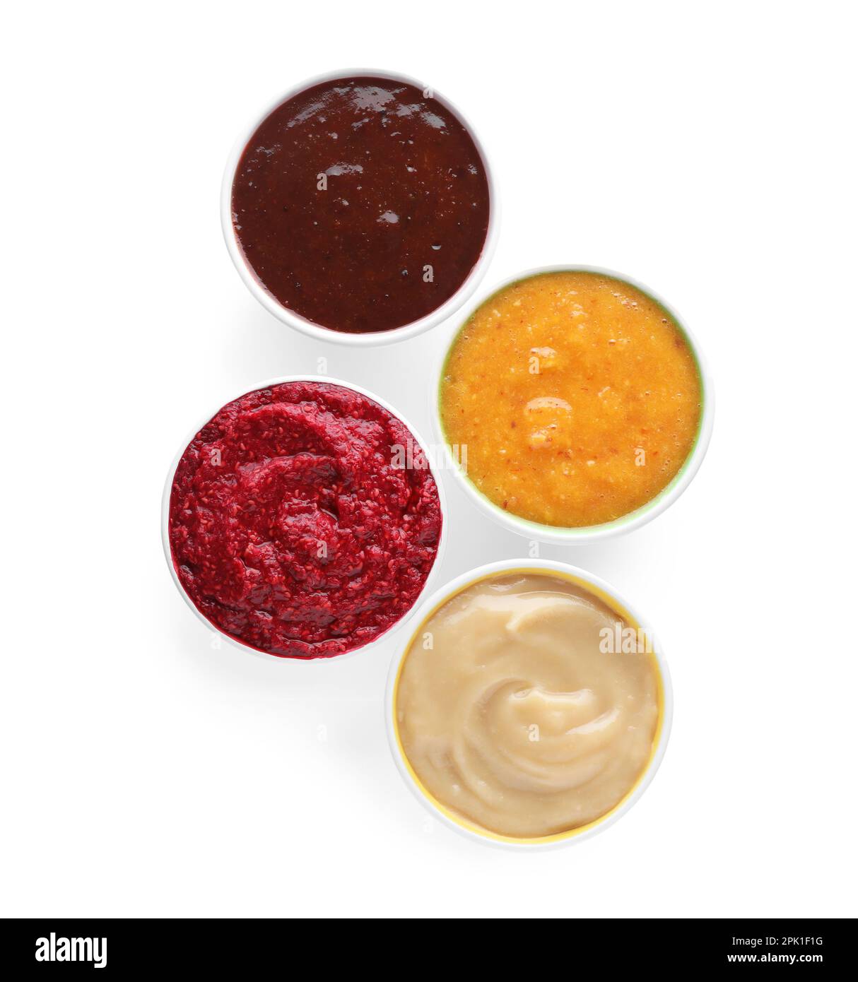 Different fruit and berry puree in bowls on white background, top view ...