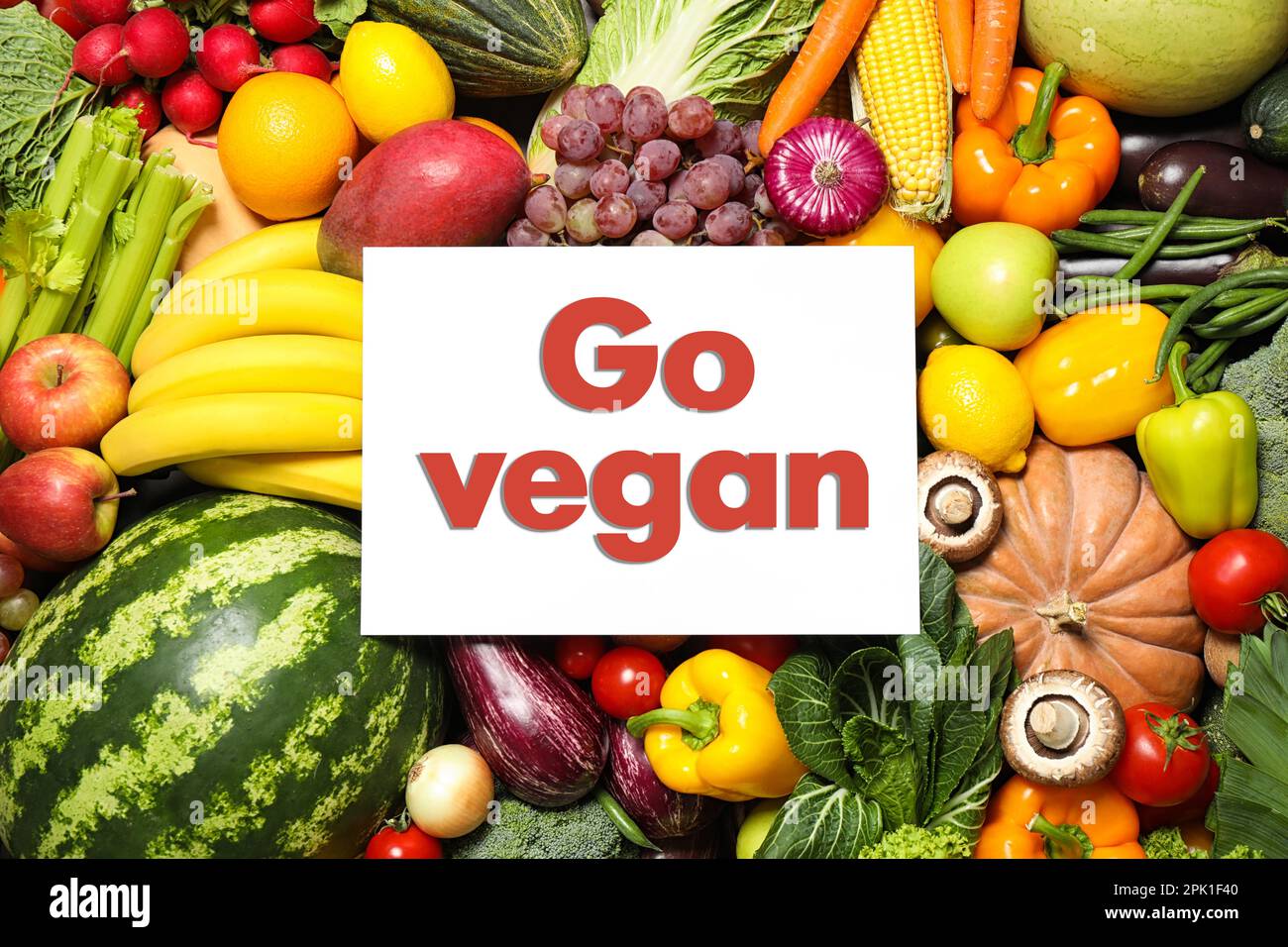 Paper card with phrase Go Vegan, fresh vegetables and fruits, top view ...