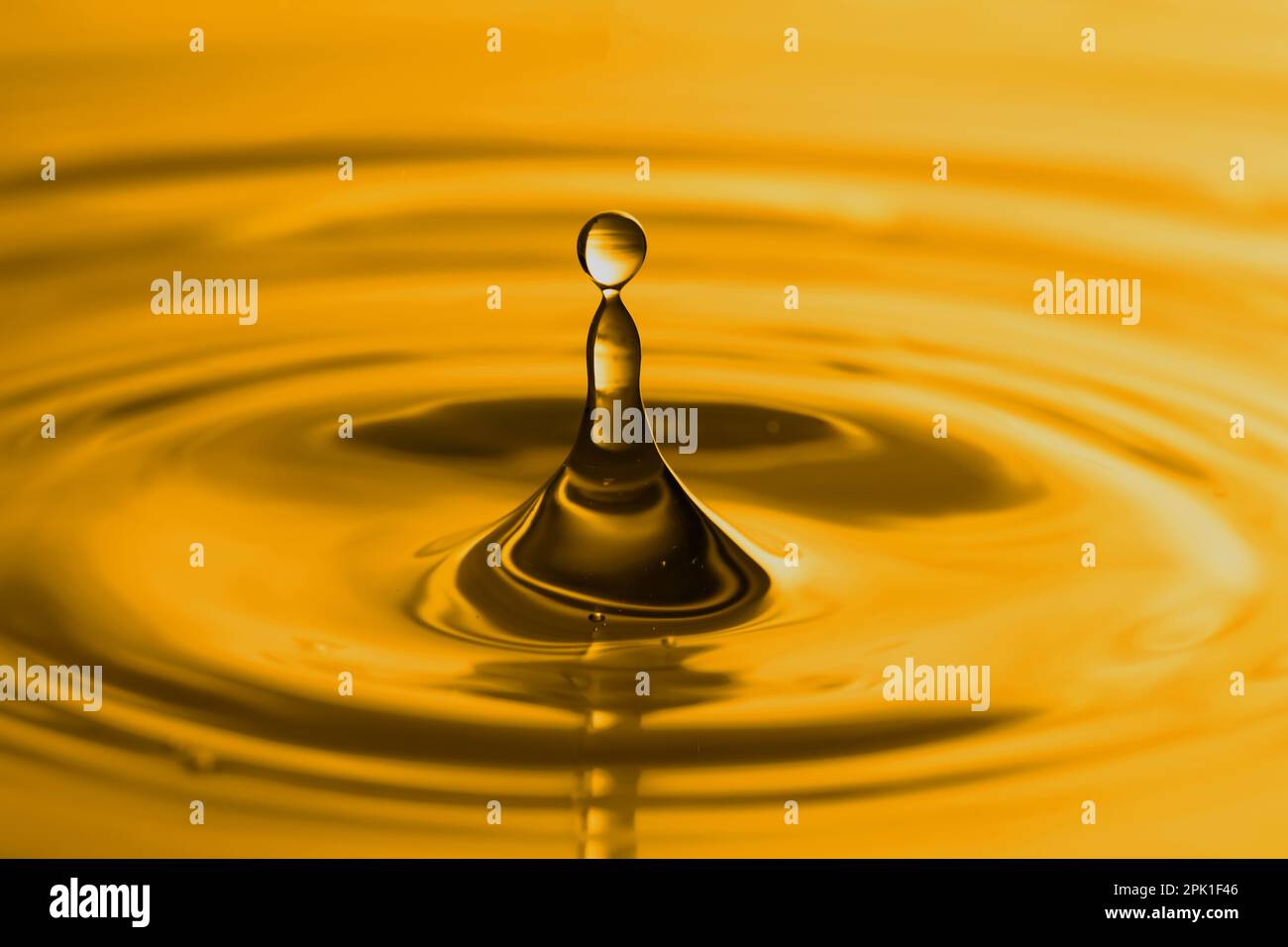 Splash of golden oily liquid with drop as background, closeup Stock ...