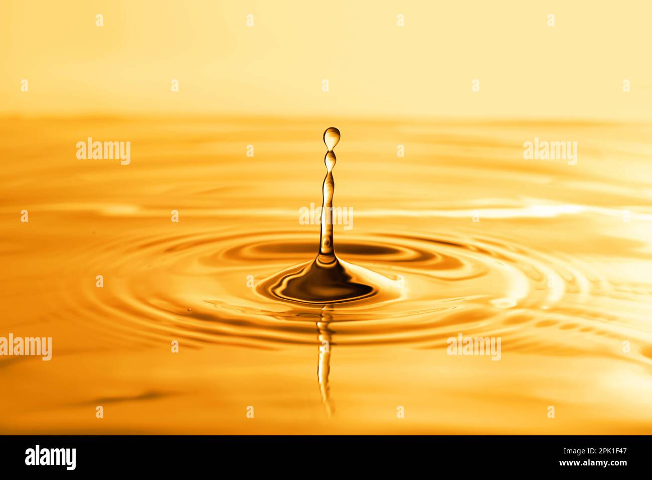 Splash of golden oily liquid with drops as background, closeup Stock ...