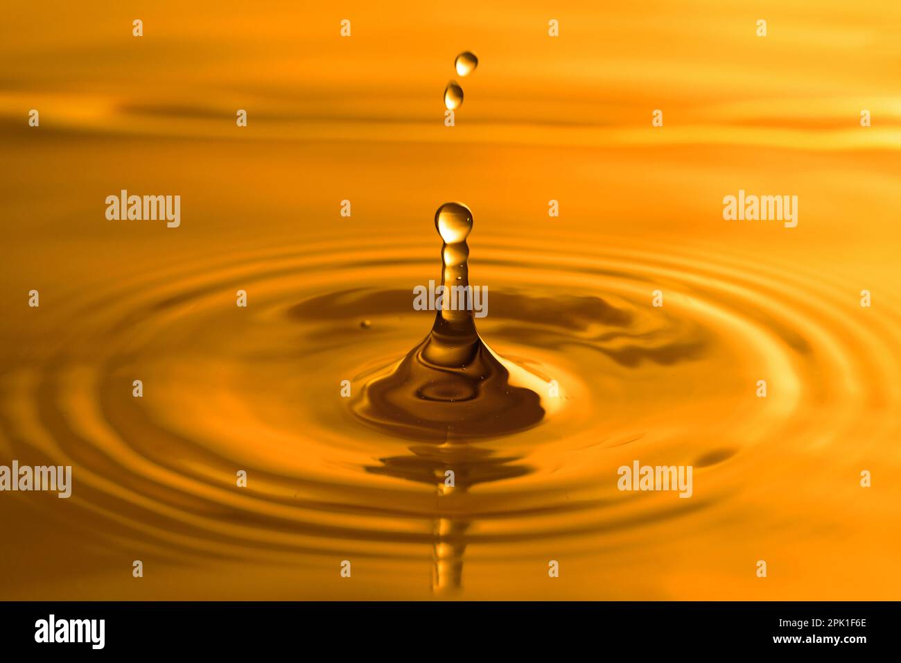 Splash of golden oily liquid with drops as background, closeup Stock ...