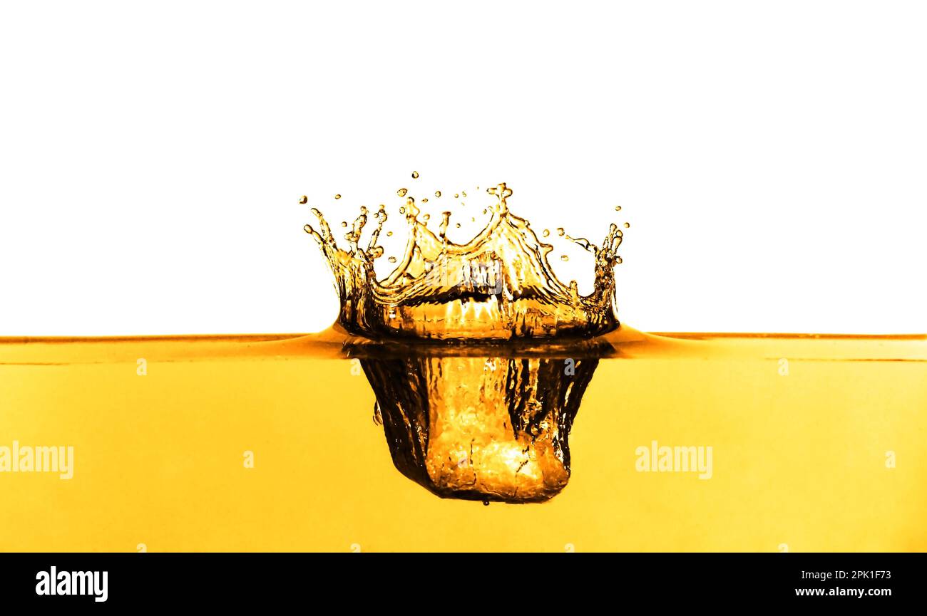 Golden oily liquid splash on white background Stock Photo - Alamy