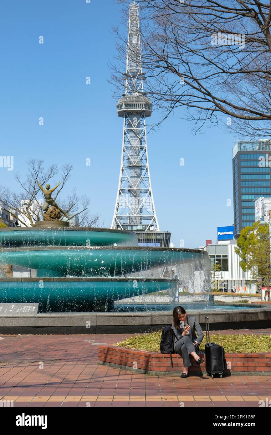 Nagoya, Japan - March 15, 2023: A woman sitting looking at her mobile ...