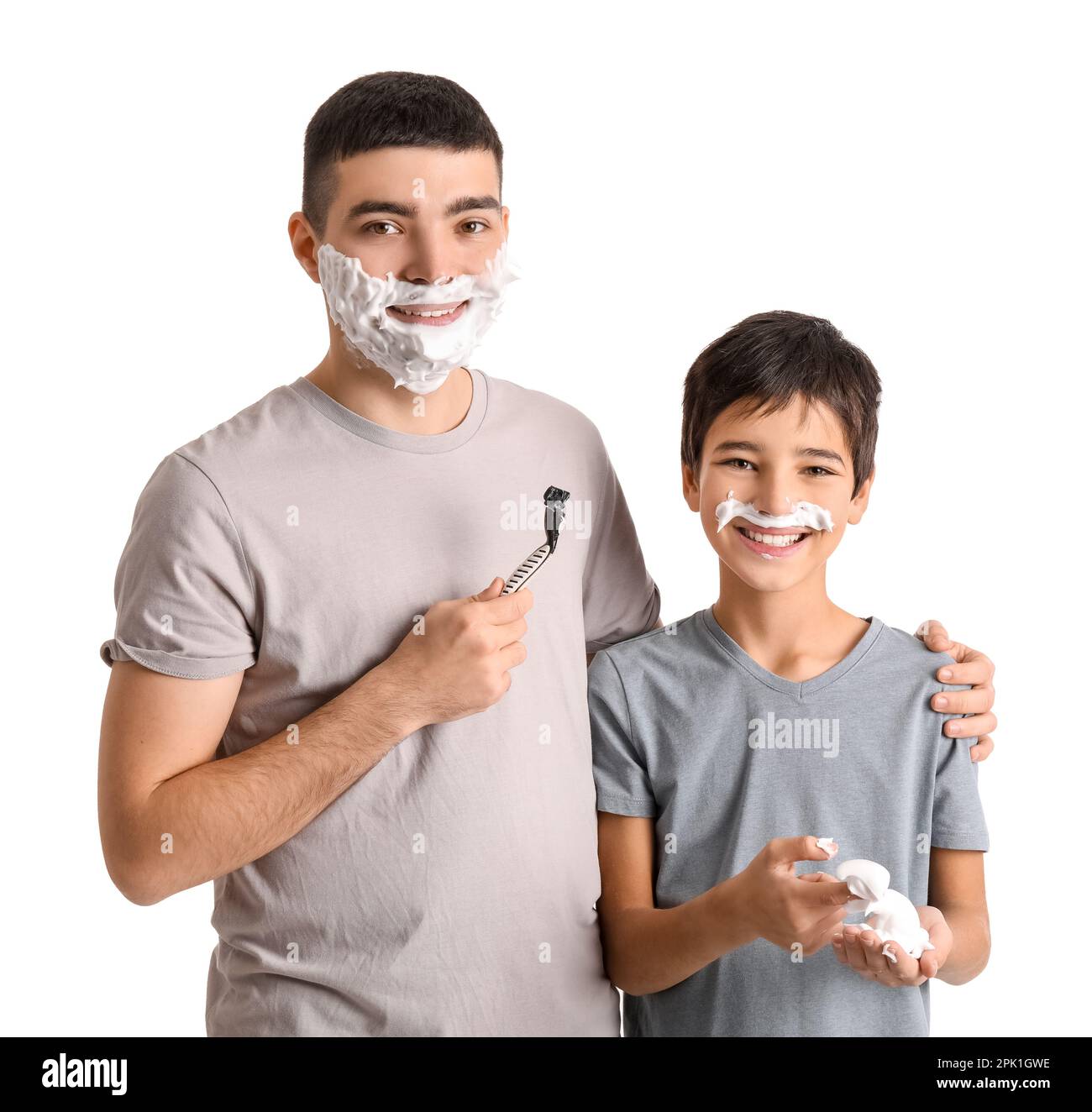 Father teaching his little son how to shave against white background ...