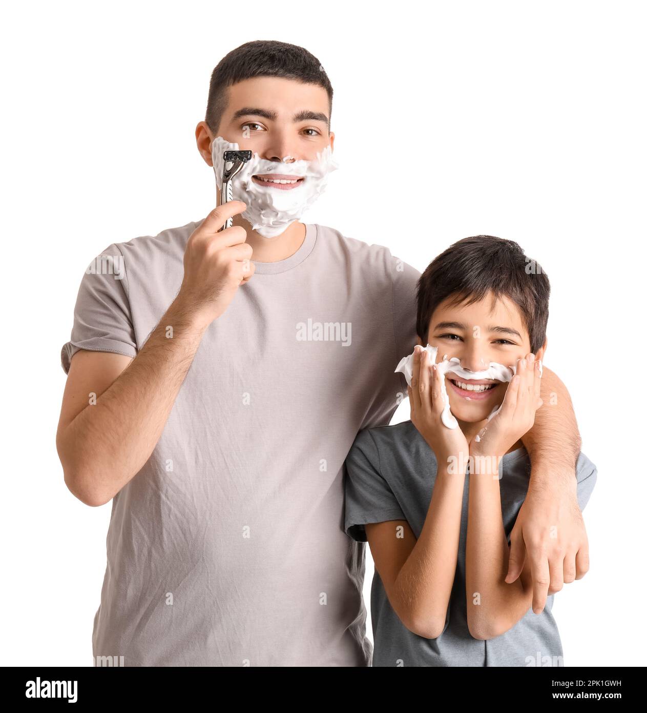 Father teaching his little son how to shave against white background ...