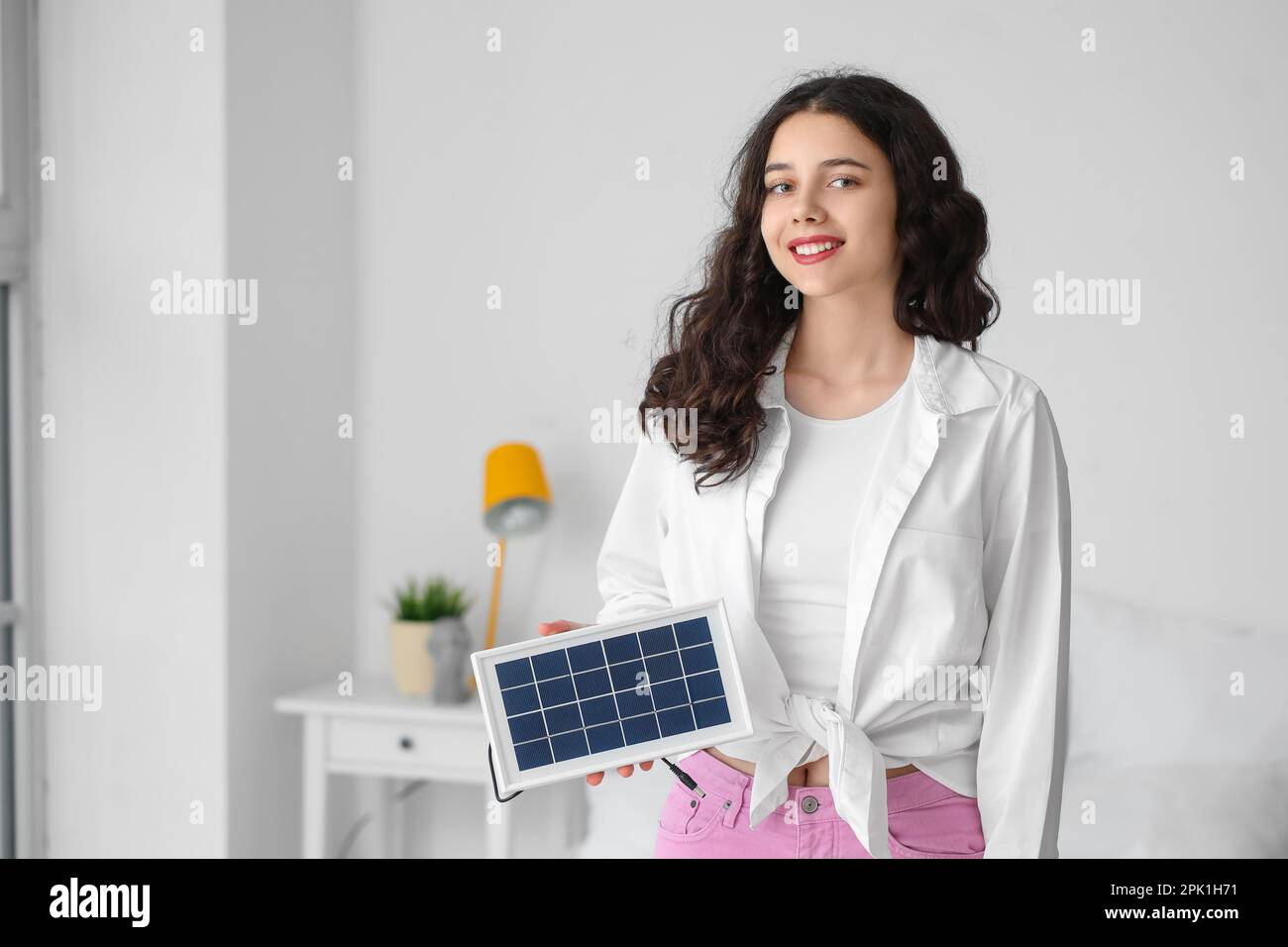 Teenage girl with portable solar panel in bedroom Stock Photo - Alamy