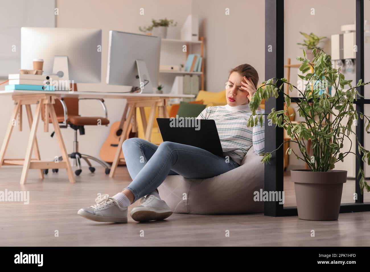 Stressed female programmer working with laptop in office Stock Photo ...
