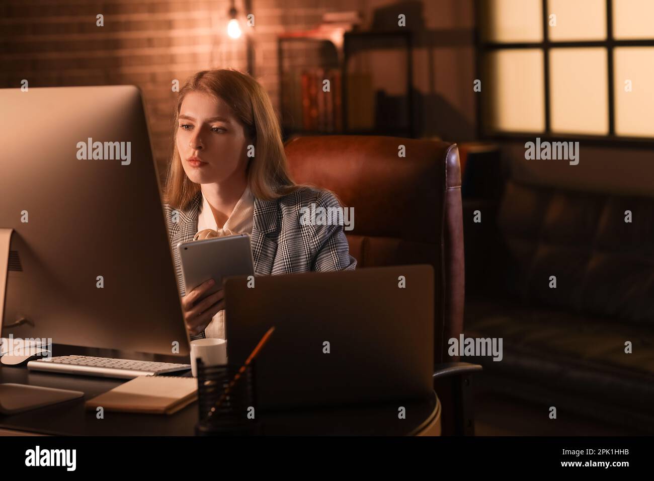 Female programmer working with computer in office at night Stock Photo ...