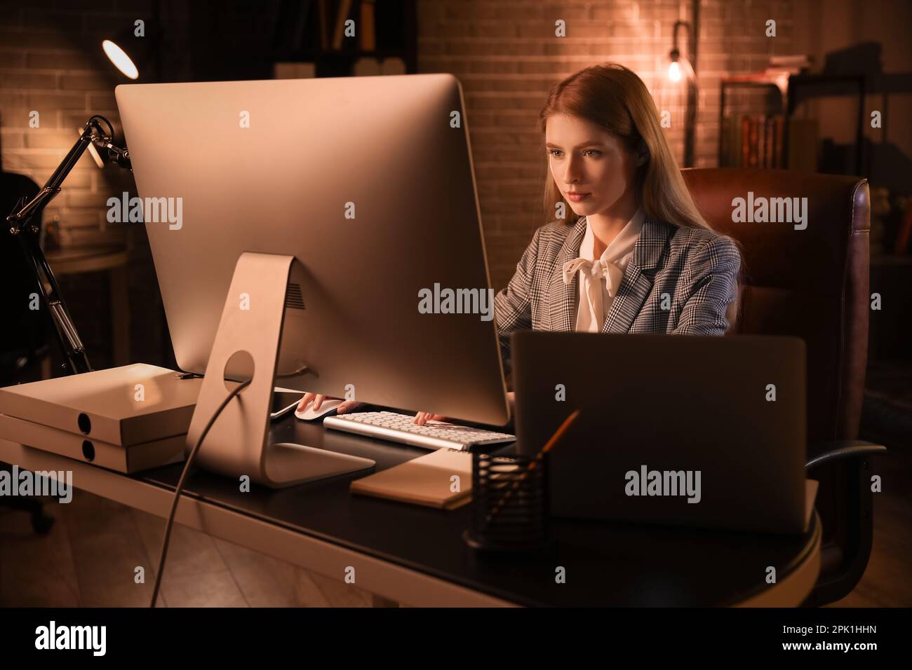 Female programmer working with computer in office at night Stock Photo ...