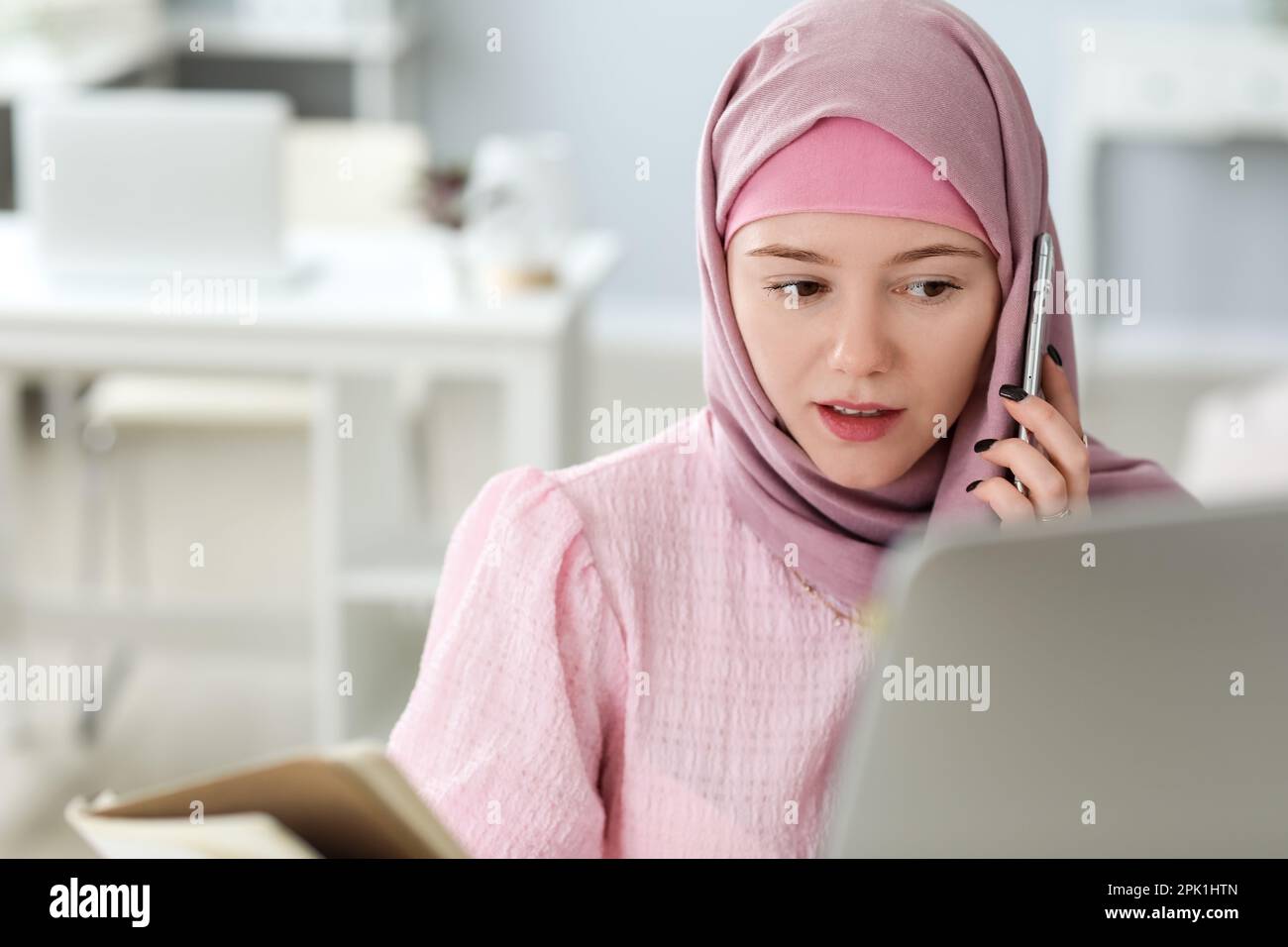 Muslim female programmer talking by mobile phone in office, closeup ...