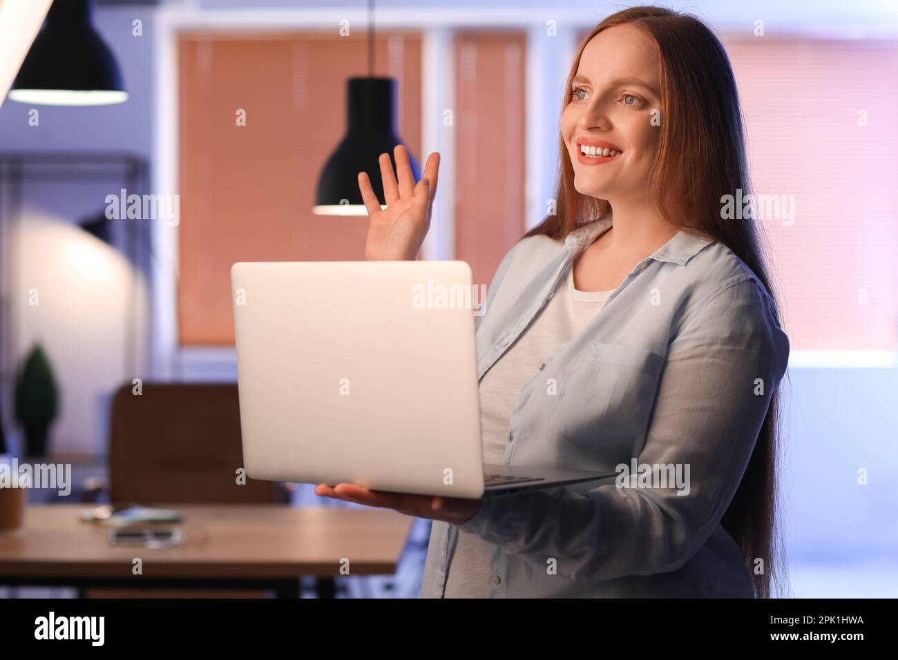 Female programmer working with laptop in office at night Stock Photo ...