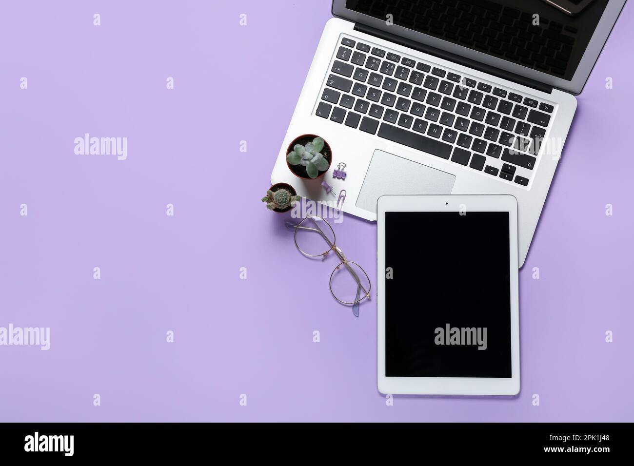 Composition with laptop, tablet and eyeglasses on lilac background ...