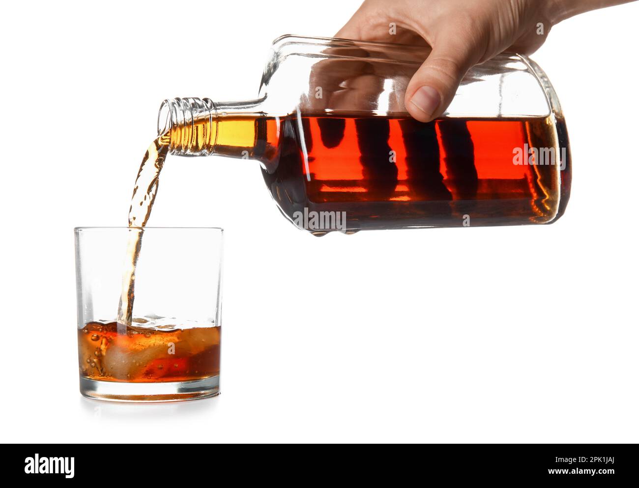 Woman pouring rum from bottle into glass on white background Stock ...