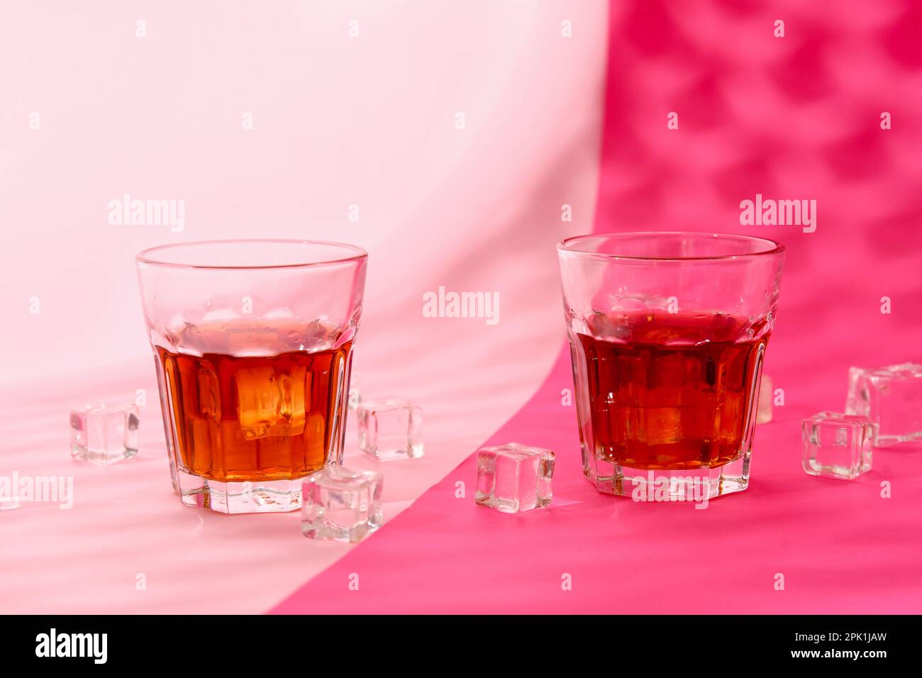 Glasses of cold rum on pink background Stock Photo - Alamy