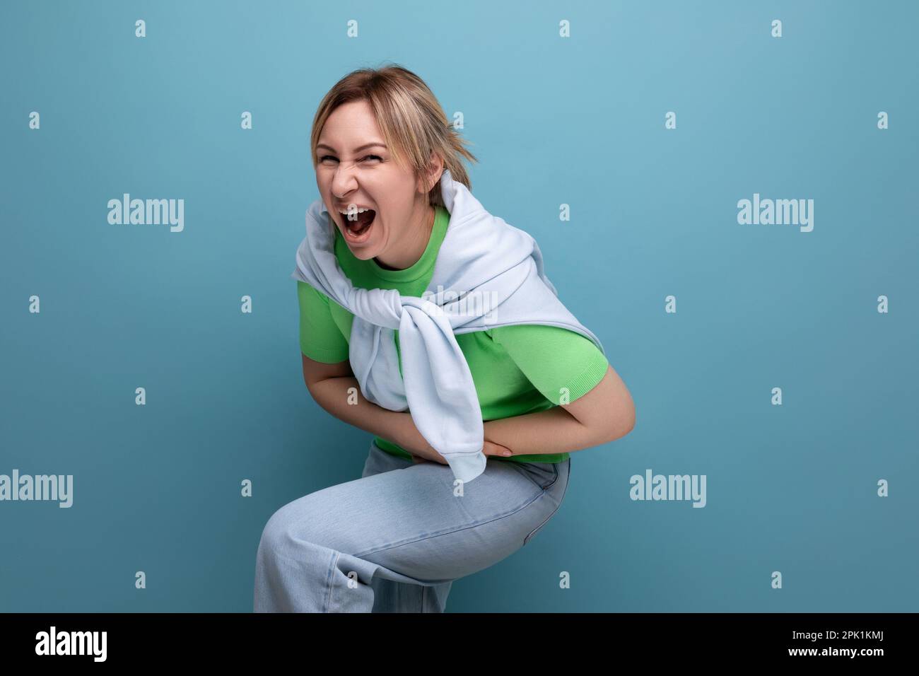 blond cheerful bright girl in a casual outfit laughing widely from a ...