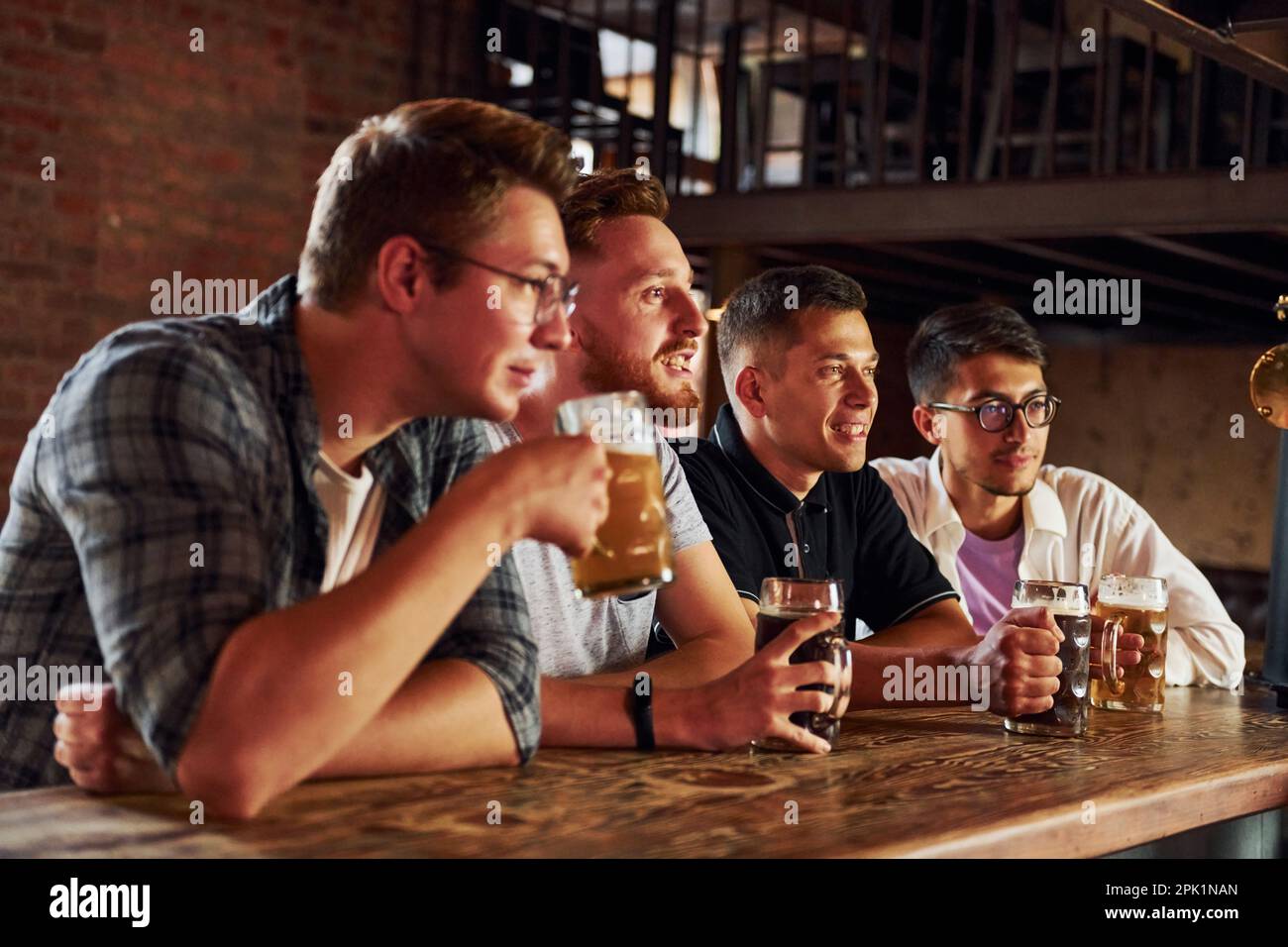 Drinking beer. People in casual clothes sitting in the pub Stock Photo ...