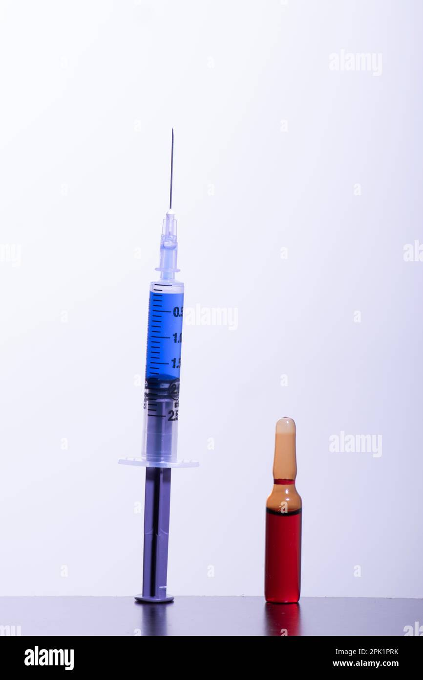 Injection and vial at table on grey background Stock Photo - Alamy