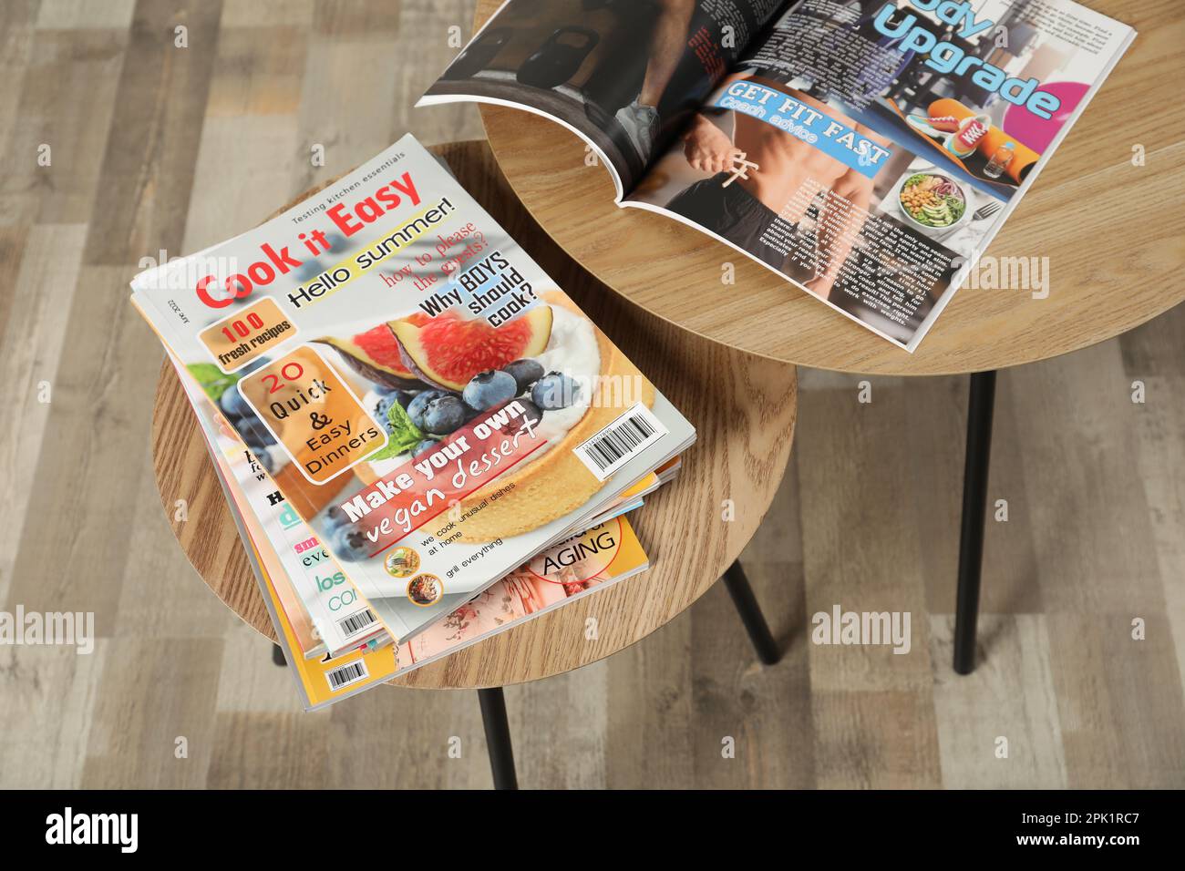Wooden nesting tables with different magazines indoors, above view ...